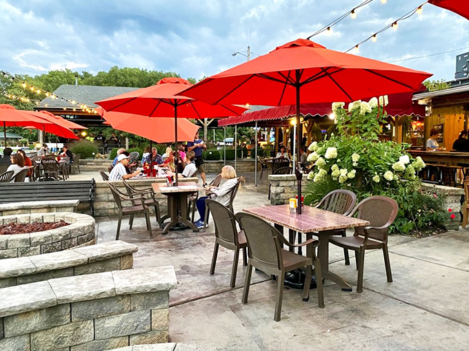 Summer perfection under red umbrellas. The patio doesn't just offer outdoor seating—it offers the soundtrack of laughter and clinking glasses.