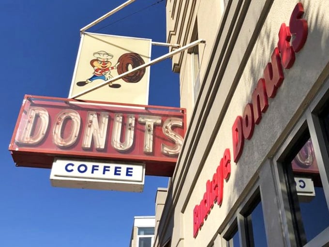 That neon sign doesn't just advertise donuts—it's a beacon of hope for the hungry, the homesick, and the hopelessly in need of sugar.