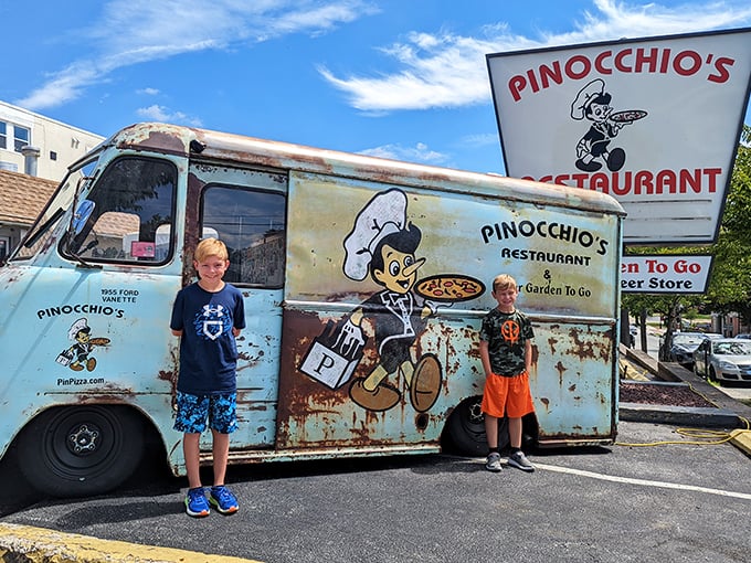 Two young pizza enthusiasts posing with the legendary truck—creating memories that will last longer than leftovers in the fridge. 