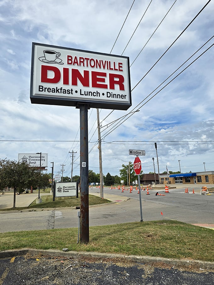 The roadside sign proudly announces "Breakfast • Lunch • Dinner" – the holy trinity of diner offerings. That coffee cup icon is practically winking at early risers driving by.
