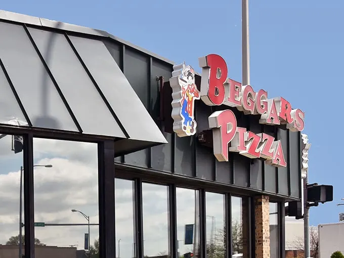 That iconic sign beckons hungry travelers like a lighthouse for the culinarily adrift – promising safe harbor for pizza and burger cravings alike.