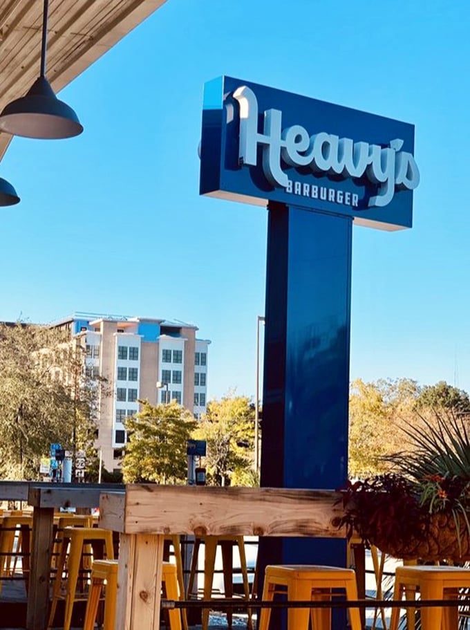 Against Charleston's blue sky, Heavy's sign stands tall – a beacon of burger hope in a world of unnecessary food complications.