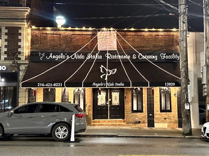 As night falls, the illuminated façade of Angelo's Nido Italia serves as a beacon for hungry travelers seeking authentic Italian comfort.