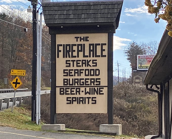 A roadside sign that cuts right to the chase: steaks, seafood, burgers, and spirits. No false advertising here—just honest promises of deliciousness ahead.