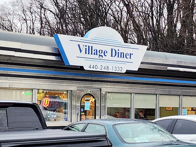 The Village Diner sign stands as a beacon of hope for the hungry, promising that inside those doors, breakfast nirvana awaits.