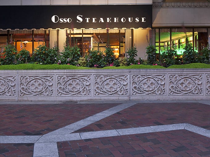 As evening falls, Osso's storefront glows like a beacon for hungry travelers, promising refuge from ordinary dining in an extraordinary setting.