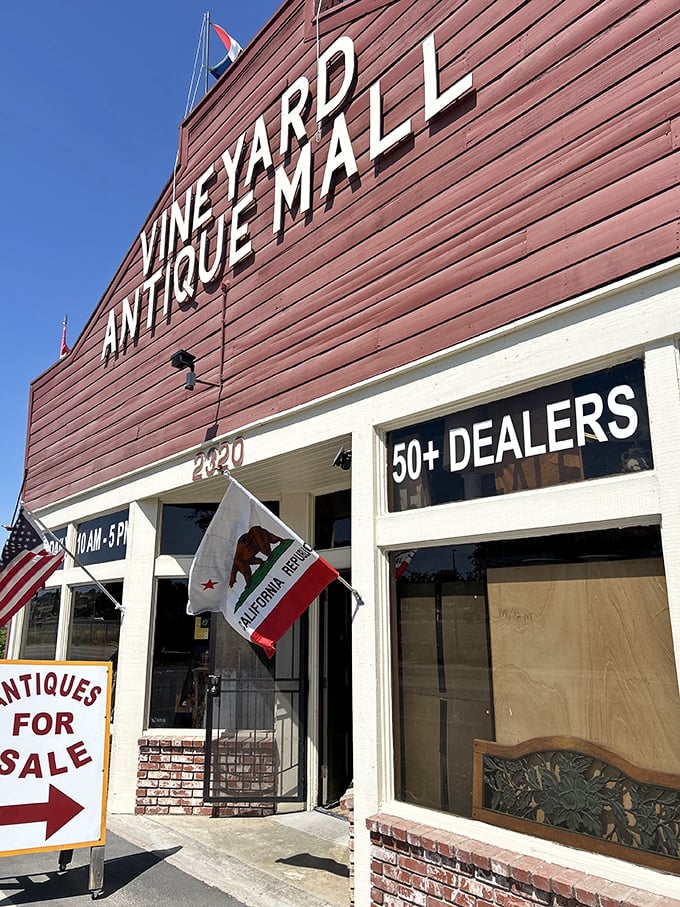 The red-painted facade announces "50+ DEALERS" like a promise of adventure, flying California's bear flag proudly alongside Old Glory.