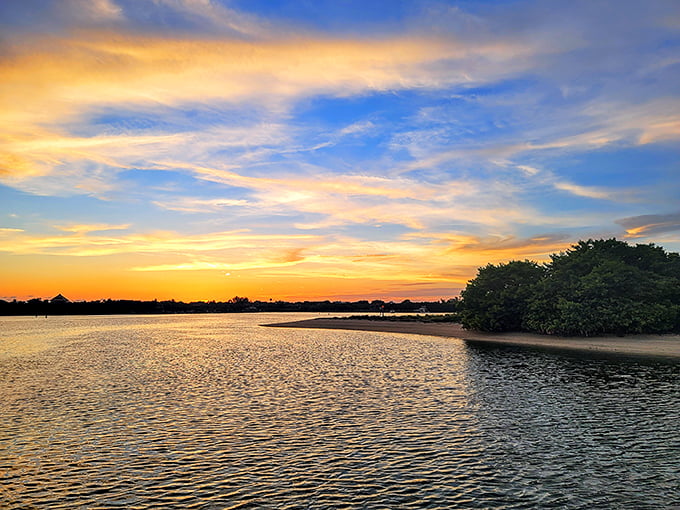 The fishing pier stretches toward the horizon, where patient anglers and sunset photographers share space in a perfect Florida coastal tableau.