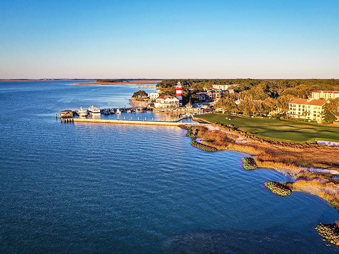 Harbor heaven! Where red-and-white lighthouse dreams meet blue-water reality at Hilton Head's postcard-perfect marina. Like finding Mayberry with yachts!