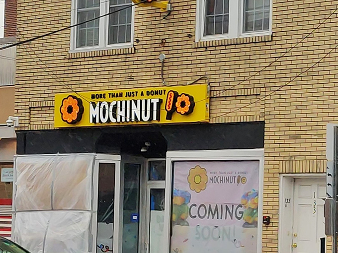 That yellow sign promises more than just donuts – it's a passport to chewy, stretchy happiness that defies physics.