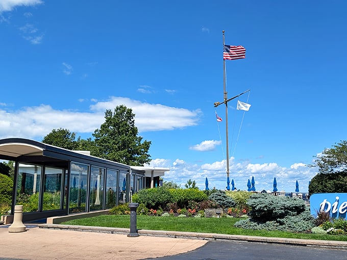 Pier W's stunning lakeside entrance, where the American flag stands tall against blue skies – seafood with a view awaits!