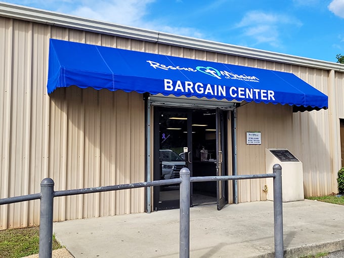 The blue awning of Rescue Mission Bargain Center beckons like a thrift treasure map. X marks the spot for bargain hunters!