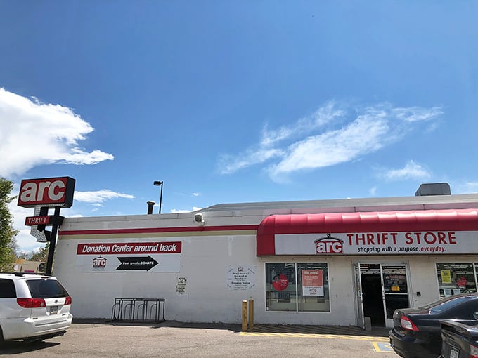 The iconic red and white arc Thrift Store sign promises treasure hunting adventures under Colorado's brilliant blue skies.