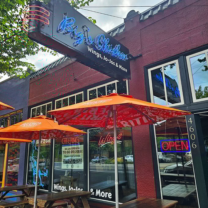 Neon promises and orange umbrellas signal serious chicken business happening behind these windows.