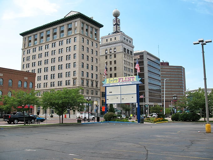 The "Enjoy Flint" sign welcomes visitors to a city where affordability meets community spirit in Michigan's urban landscape.