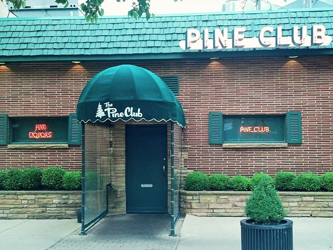 The Pine Club's iconic green awning and brick exterior – like a secret clubhouse where the password is "medium-rare."