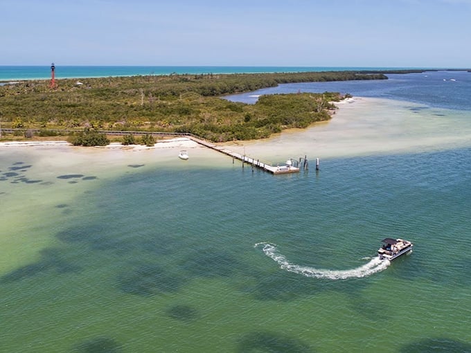 Paradise from above: crystal-clear waters embrace pristine shorelines while a lone boat creates ripples in this untouched slice of Old Florida.