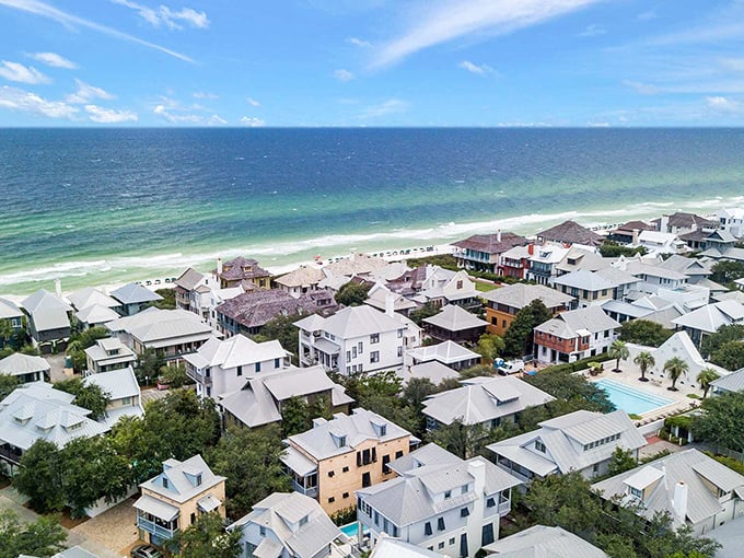 From above, Rosemary Beach reveals its perfect harmony—pristine white homes nestled between emerald waters and lush greenery. Beach real estate poetry.