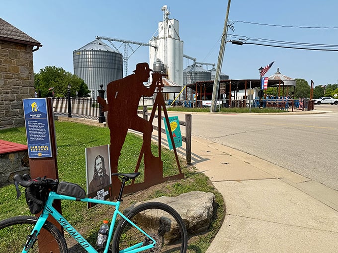 That metal silhouette isn't just art—it's a nod to the surveyors who first mapped this land, standing sentinel as grain silos rise in the background.