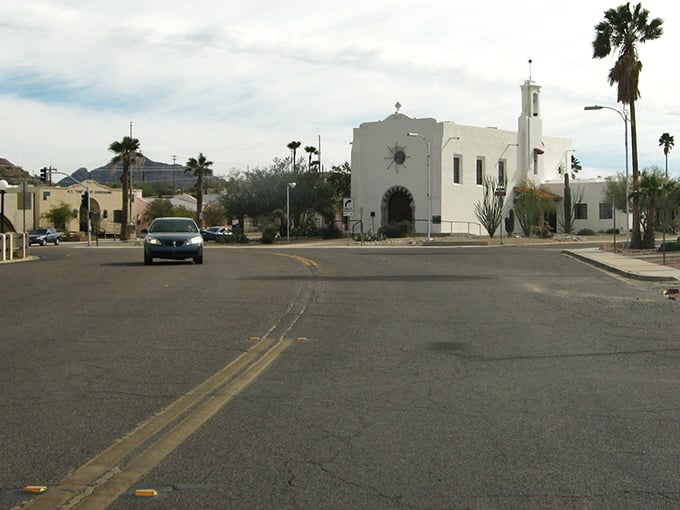 Ajo's plaza unfolds like a perfectly composed postcard—palm trees, Spanish Colonial architecture, and mountains that look painted by a particularly ambitious Bob Ross.