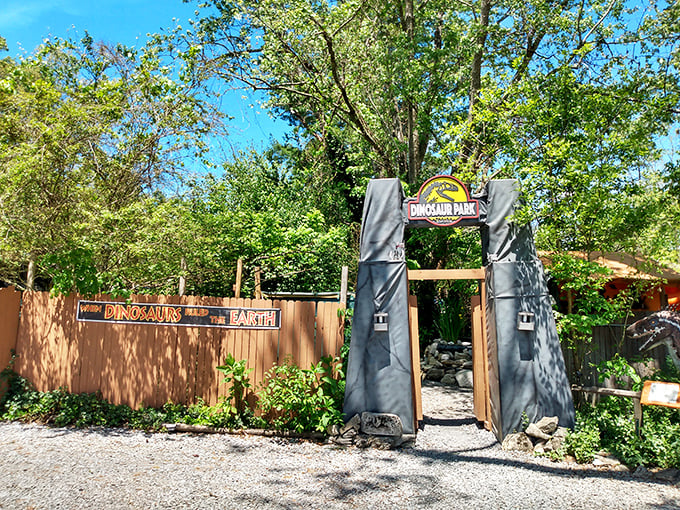 The park's entrance channels pure "Jurassic Park" nostalgia with its wooden gates and iconic signage, promising prehistoric adventures beyond the threshold.