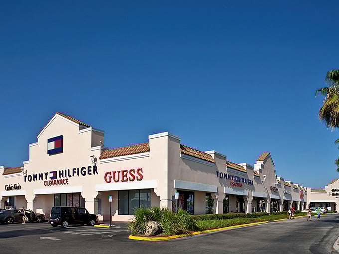 Tommy Hilfiger and Guess stand shoulder-to-shoulder like old friends, inviting you to explore their discounted designer treasures under the brilliant Florida sky.