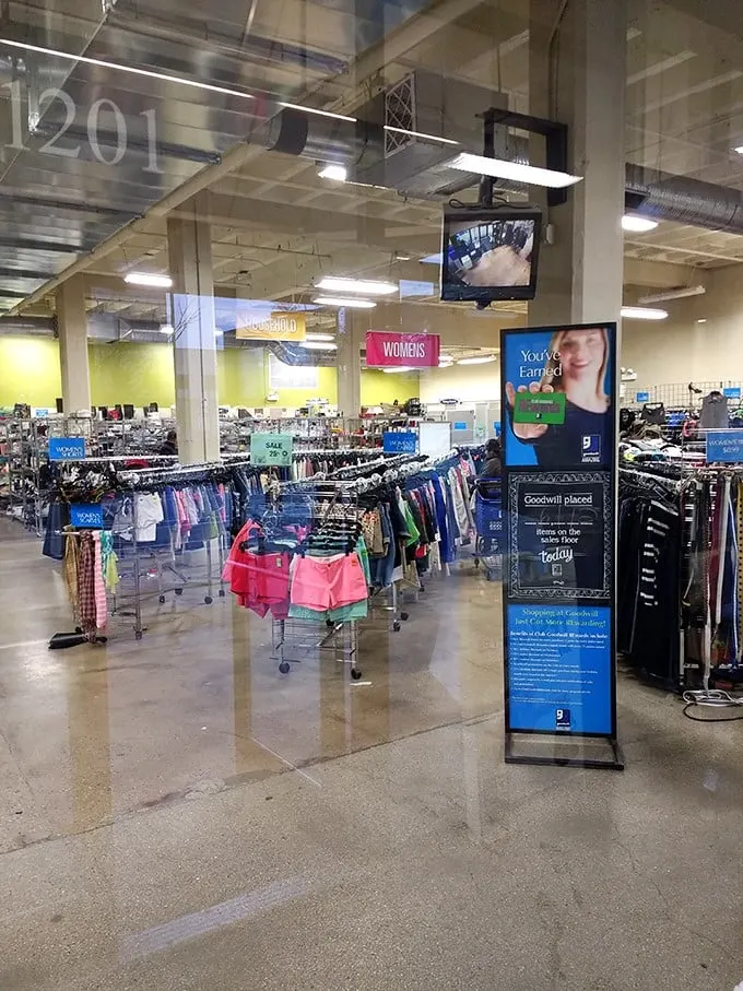 A thrifter's paradise stretches before you—racks organized with military precision but hiding secrets only the patient will discover.