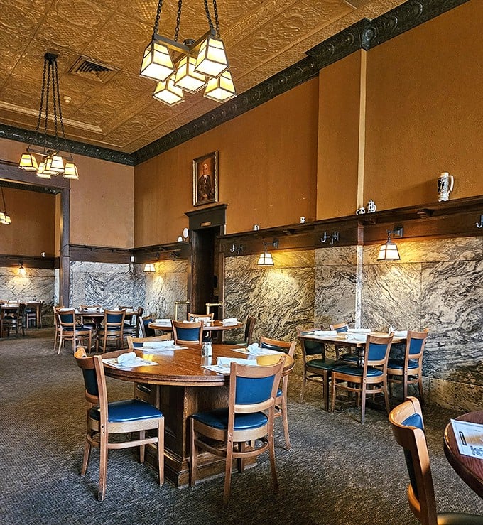 Step inside and time slows down – marble wainscoting meets warm wood and craftsman lighting in a dining room that whispers stories of celebrations past.
