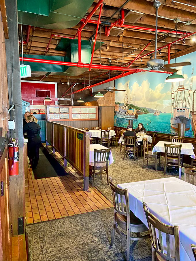 Step inside and discover a maritime wonderland where exposed wooden beams, red pipes, and that stunning harbor mural transport you to a seaside haven.