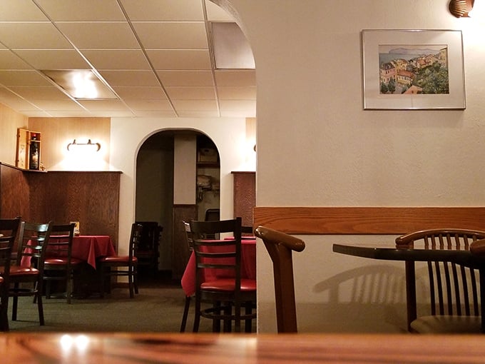 Step into this cozy dining room where red tablecloths and warm lighting create pure Italian comfort magic.