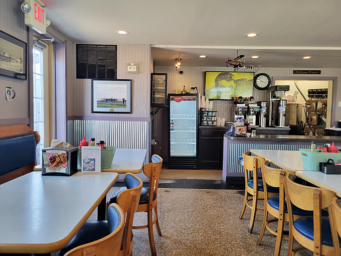 Classic diner charm with aviation flair—where corrugated metal meets comfort food, and every seat offers a view of culinary magic in action.