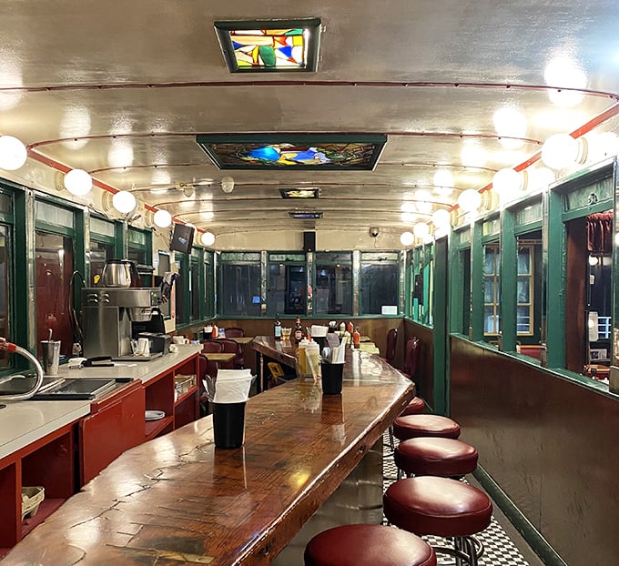 Step inside and the train car illusion continues—polished wood counter, vintage stools, and globe lights creating a cozy capsule of comfort food bliss.