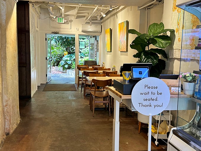 Step inside to a space that balances rustic Wine Country with modern café cool. Plants, natural light, and that "please wait to be seated" sign that promises good things ahead.