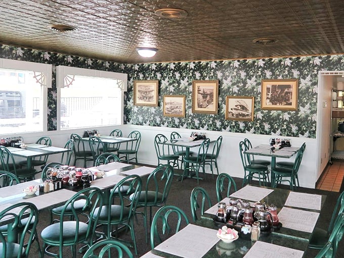 Green chairs, vintage wallpaper, and framed nostalgia create the perfect backdrop for the serious business of breakfast consumption.