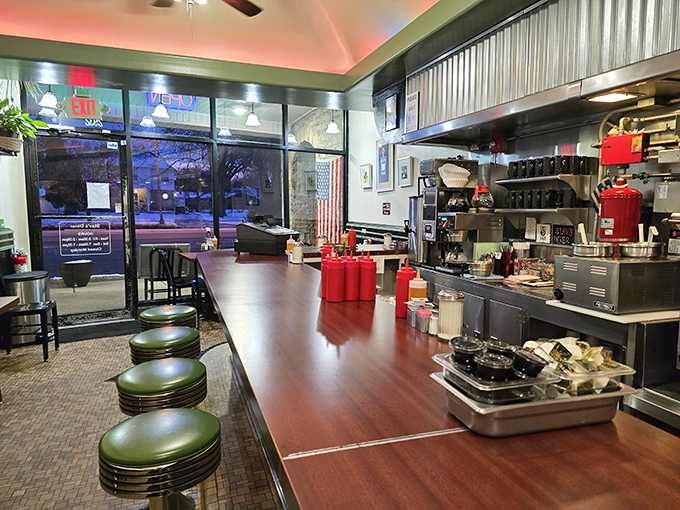 Where diner magic happens—green vinyl stools at a polished counter offering front-row seats to the breakfast theater. The corrugated metal adds just the right touch of nostalgic charm.