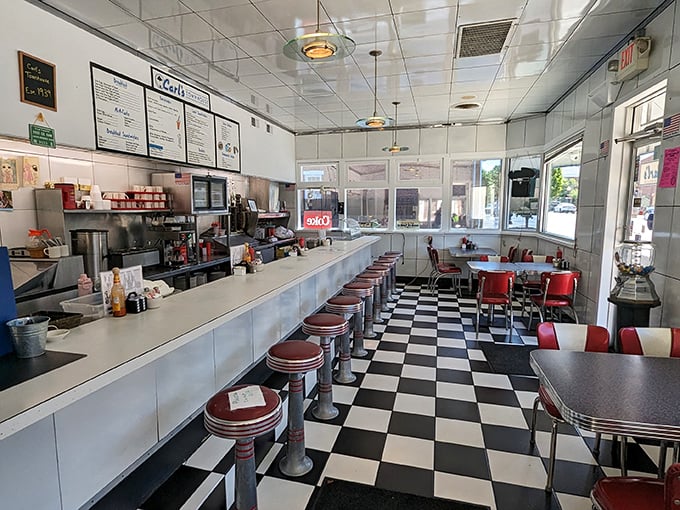 The checkerboard floor and red vinyl stools aren't retro by design—they're authentic survivors from an era when diners were America's living rooms.