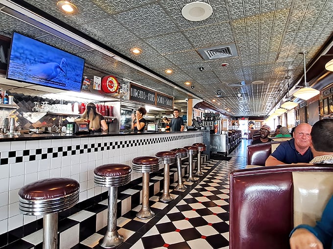The classic black and white checkered floor and chrome counter stools aren't just decoration—they're a visual guarantee that comfort food greatness awaits.