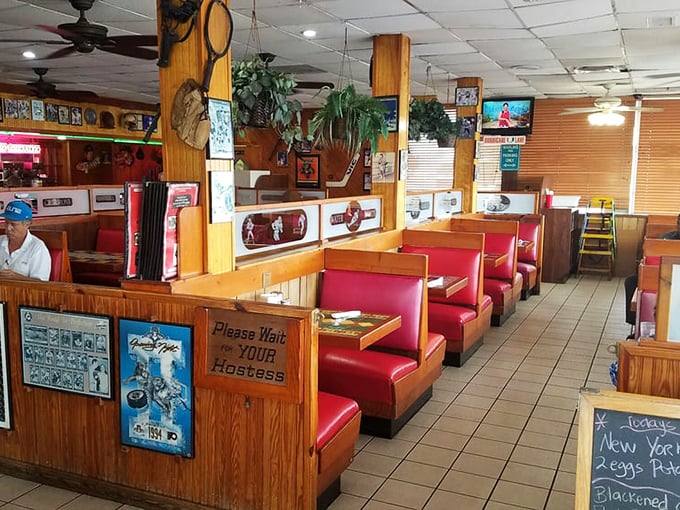 Classic red vinyl booths and wood paneling create that timeless diner atmosphere where conversations flow as freely as the coffee.