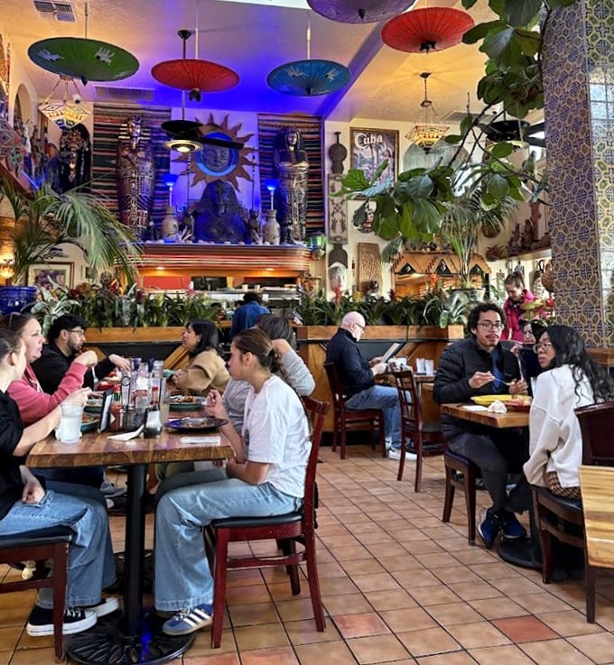 Step inside and the world expands—colorful parasols, global artifacts, and lush greenery create a dining atmosphere that's part jungle, part art gallery.