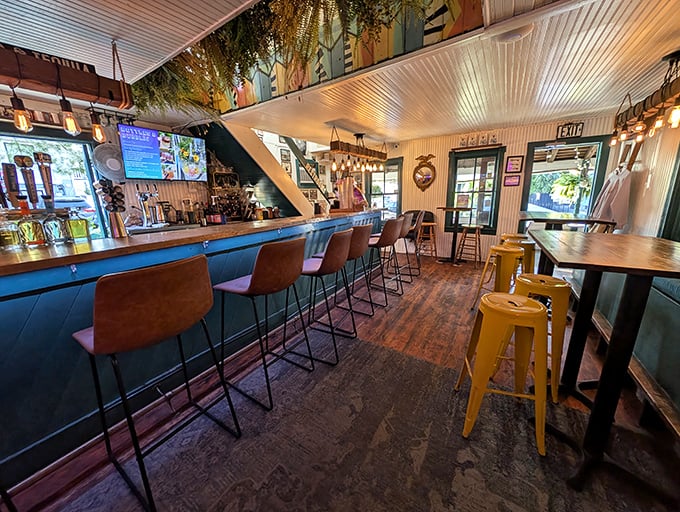 The interior combines rustic wooden floors with pops of yellow metal stools, creating a space that feels both beachy and intimate—like your coolest friend's vacation home.