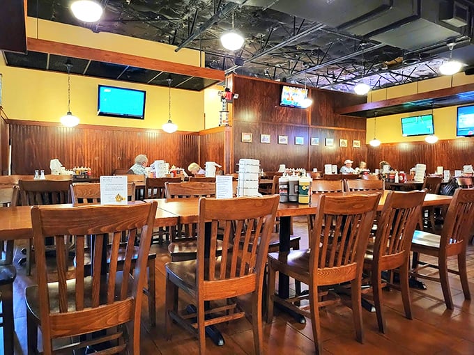 Wooden chairs, warm lighting, and TVs strategically placed for game day. This dining room isn't trying to be fancy—it's trying to make you comfortable while you feast.