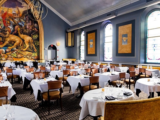 Blue walls and white tablecloths frame that show-stopping hunting mural—dining room or Renaissance museum? Either way, you're in for a masterpiece.