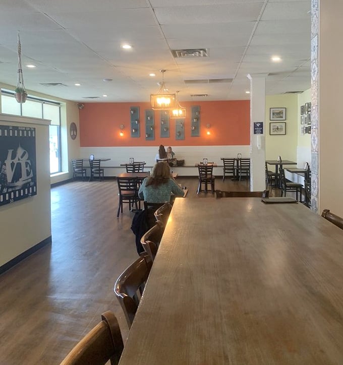 Warm coral walls, wooden tables, and that "LOVE" sign say it all – this isn't just a restaurant, it's a community living room where memories are made between bites.
