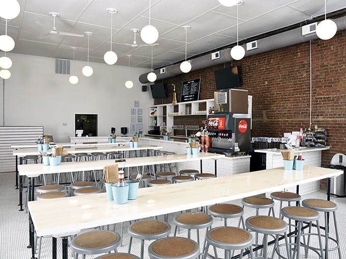 Clean lines, communal tables, and that exposed brick wall—a temple of simplicity where the chicken, not the decor, does the talking.