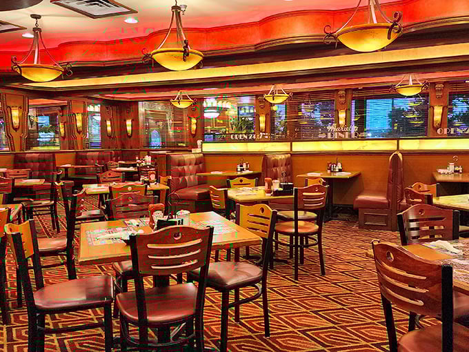 Warm amber lighting bathes burgundy booths in a golden glow, creating the perfect setting for life-changing conversations and food epiphanies.