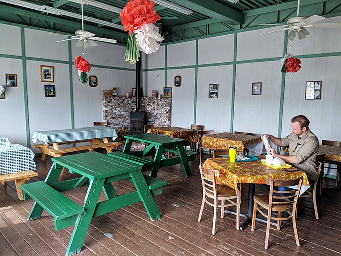 Inside, wooden picnic tables and paper flower decorations create a homey atmosphere that feels like dining in a friend's mountain cabin.