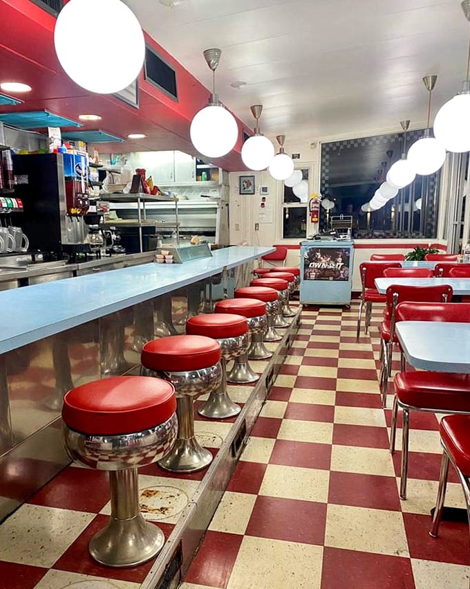 Red vinyl stools lined up like soldiers ready for the breakfast brigade. That checkerboard floor has witnessed countless coffee refills.