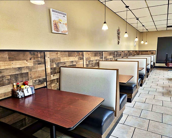 Classic diner booths with rustic wood paneling create that perfect small-town atmosphere where conversations flow as freely as the coffee.