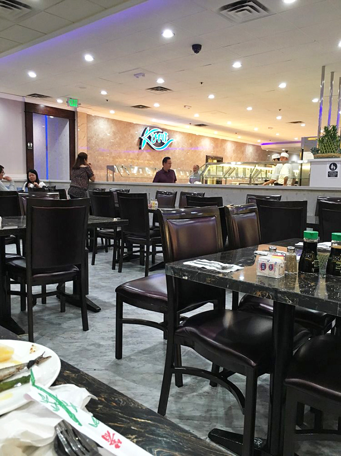 Modern elegance meets casual comfort inside Kumi. The neon fish sign glows with promise of seafood delights to come.