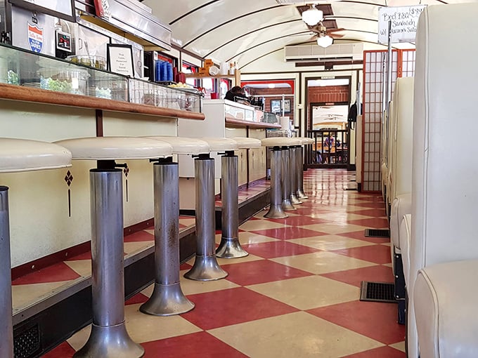 Chrome stools lined up like soldiers along that classic checkerboard floor – this isn't retro-inspired décor, folks, it's the real vintage deal.